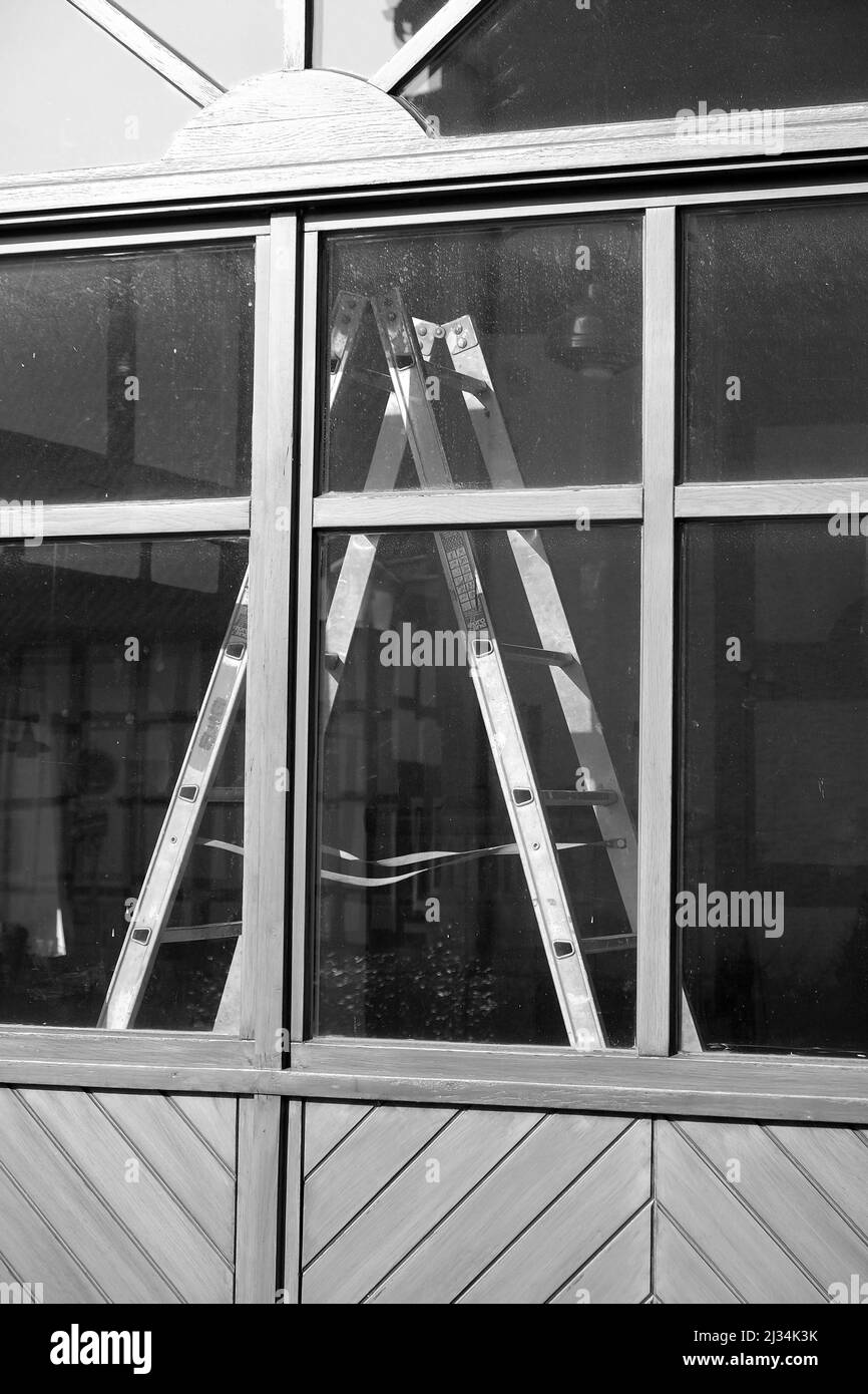 A grayscale view of a ladder behind a glass window Stock Photo - Alamy