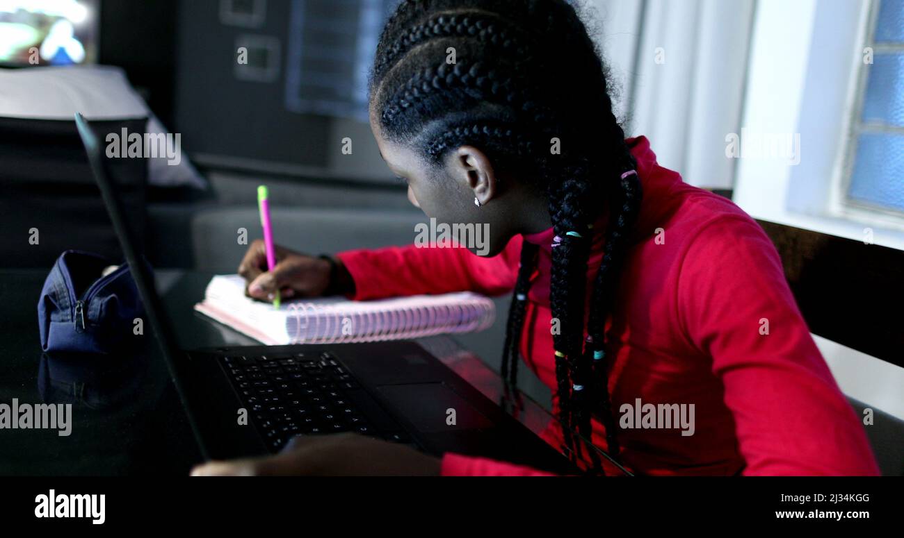 Teen African girl doing homework at night, black adolescent female ...