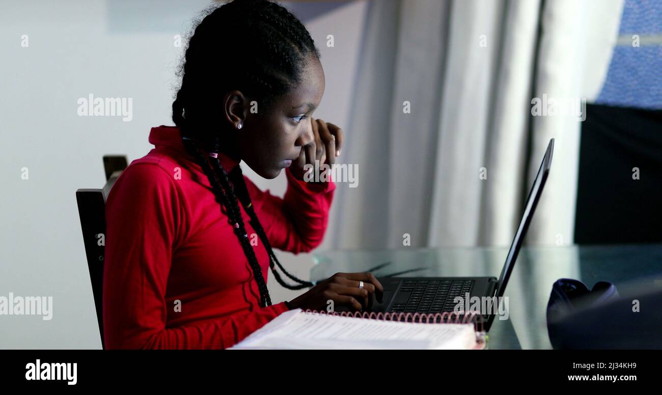 Teen African girl doing homework at night, black adolescent female ...