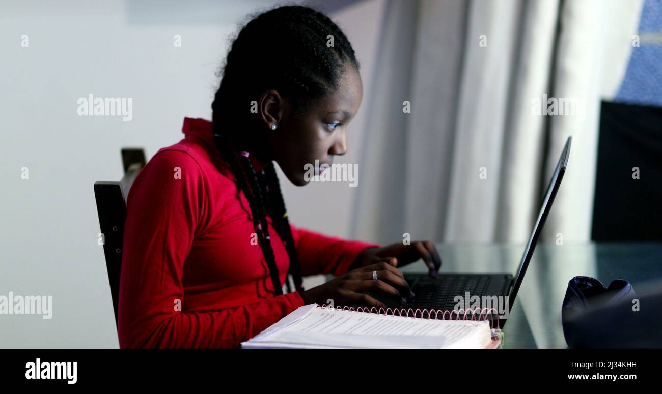 Teen African girl doing homework at night, black adolescent female ...