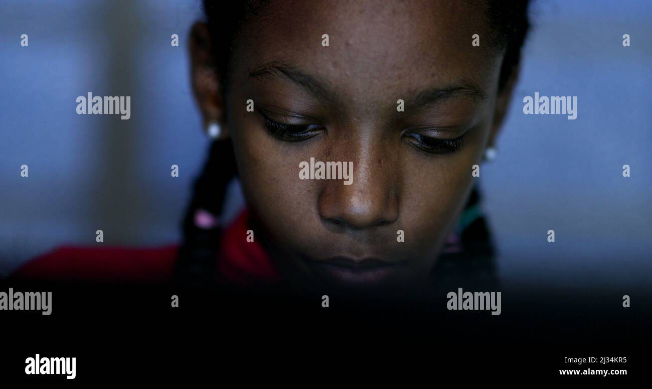 Teenager looking at computer screen at night browsing internet, black ...