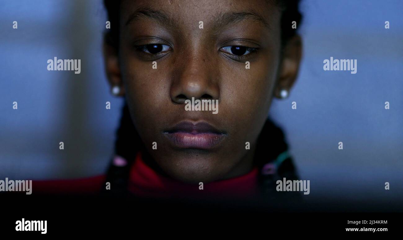 Teenager looking at computer screen at night browsing internet, black ...