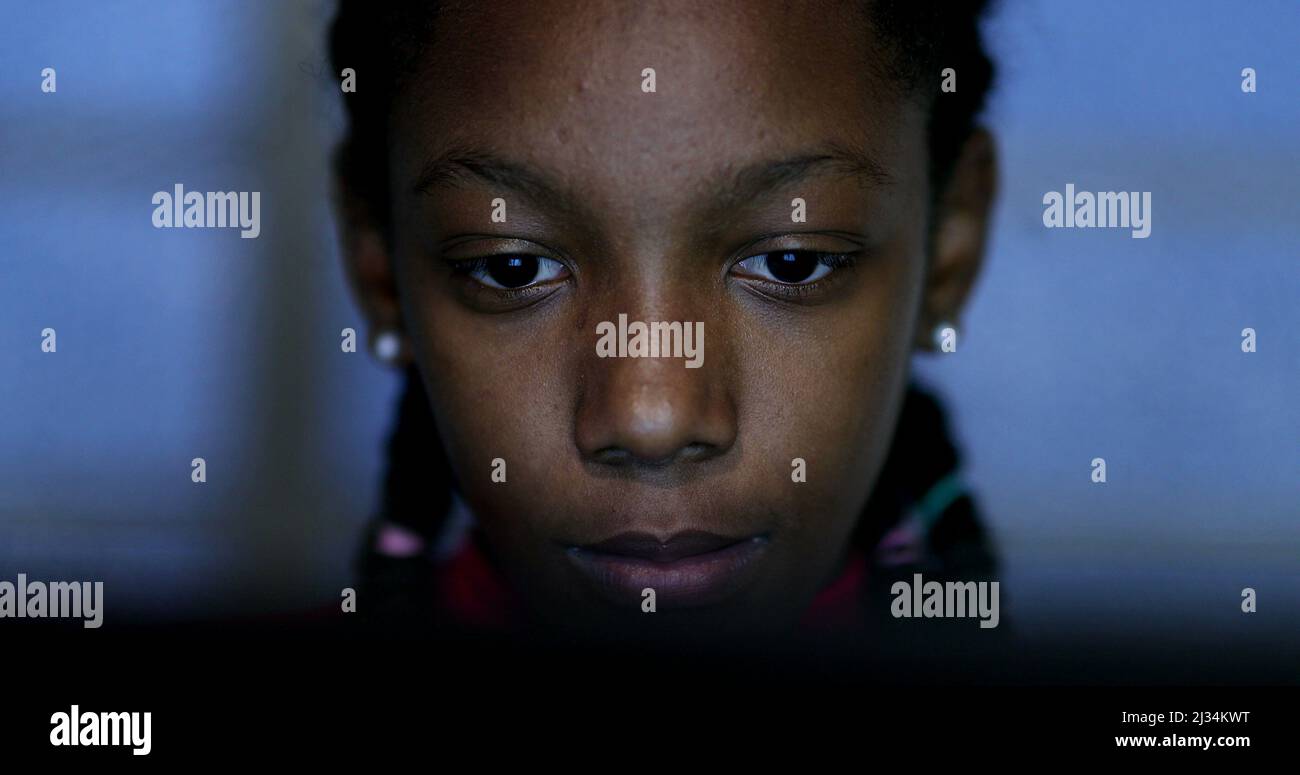 Teenager looking at computer screen at night browsing internet, black ...