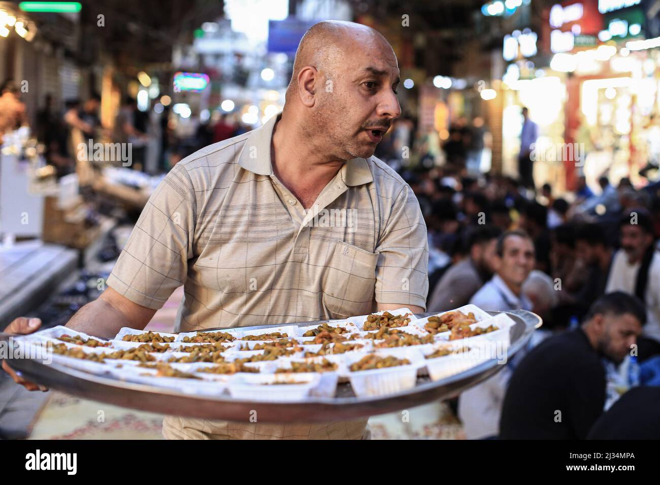 Baghdad, Iraq. 05th Apr, 2022. A volunteer serves food for the Iftar ...
