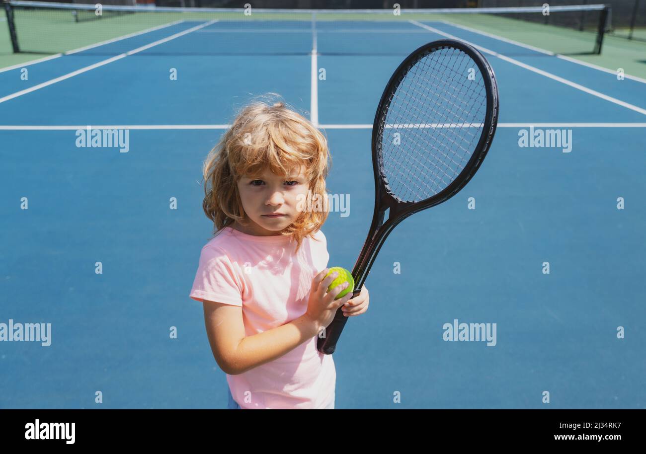 Child with tennis racket and ball on tennis court outdoor. Sport ...