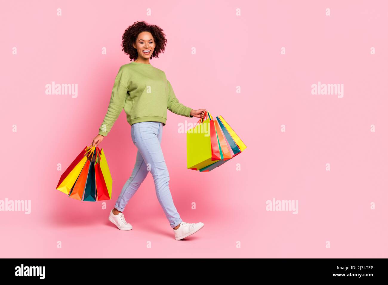Full size profile side photo of young pretty girl go hold shopping bags ...