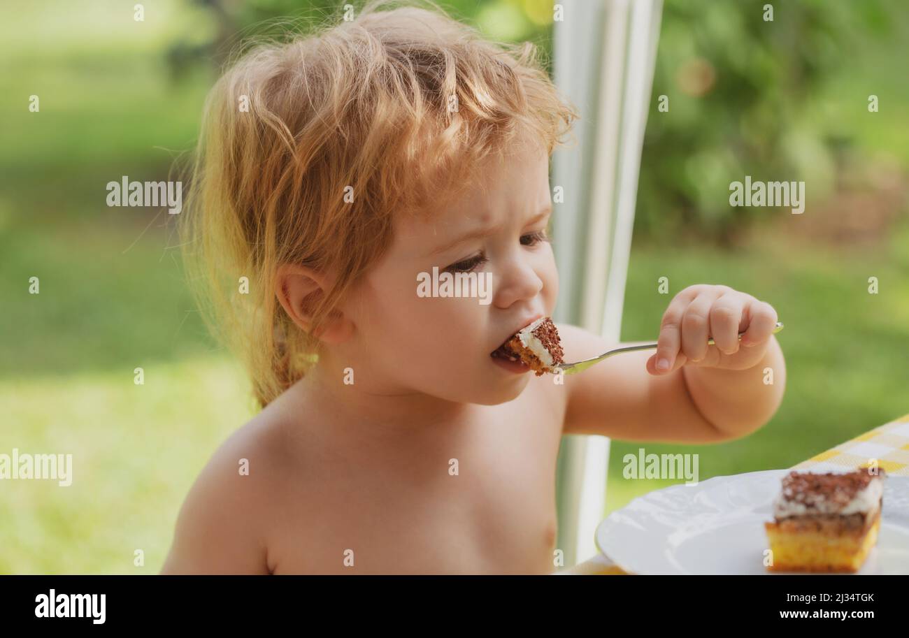 Baby eating cake. Funny cute little boy eat sweet cake. Child eating ...