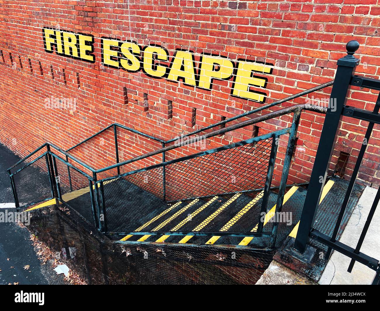 a fire escape red brick wall sign warning staircase outside stairs ...