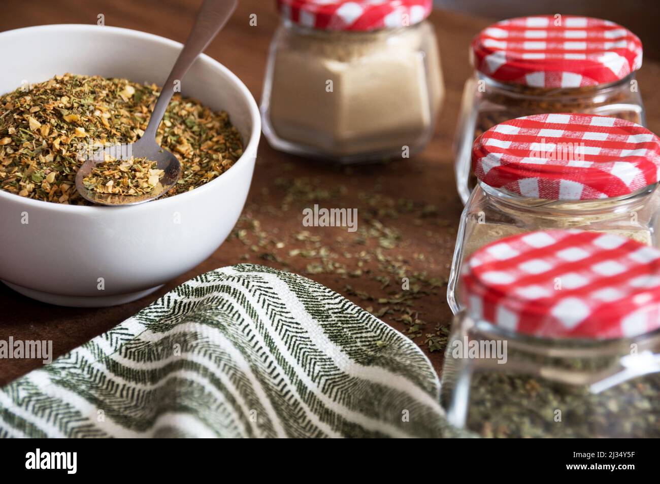 Red lid condiment jars lined up and out of focus and bowl on left side ...