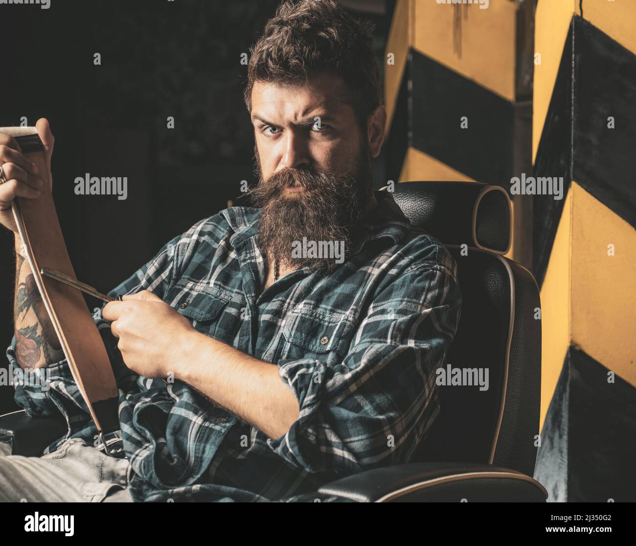Beard man sharpens the razor in barber shop. Razor sharp. Shaving man ...