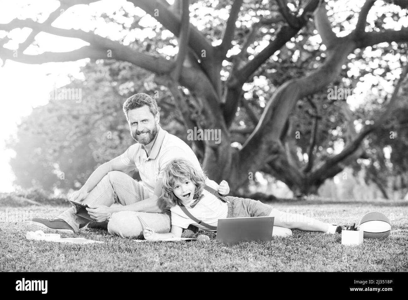 Outdoor education. Father and son use laptop, dad and school boy child ...