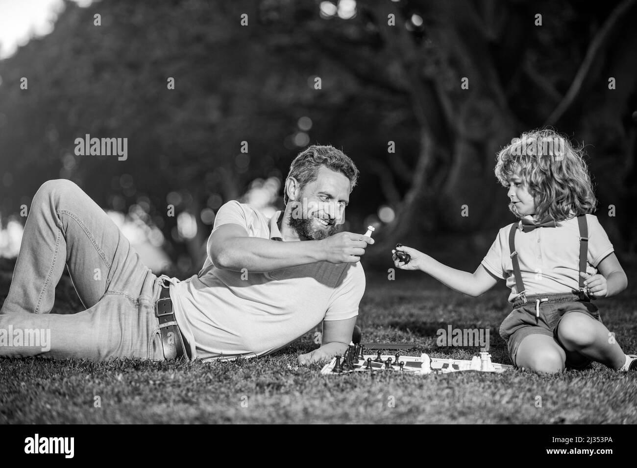 Father and son playing chess spending time together outdoor. Men like ...