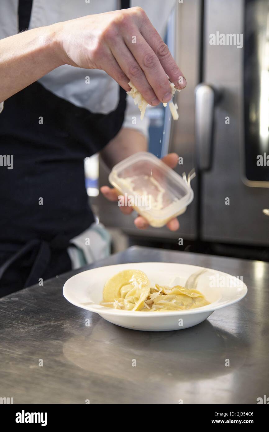 A chef making a pancake steak tartare with cheese in a kitchen Stock ...