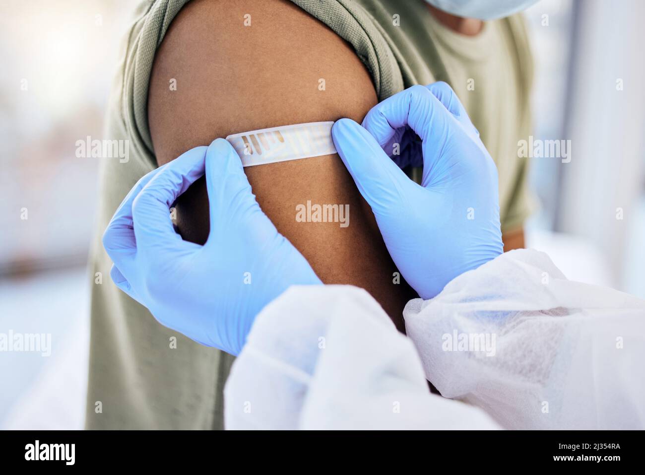 All done. Cropped shot of an unrecognizable doctor placing a plaster on ...