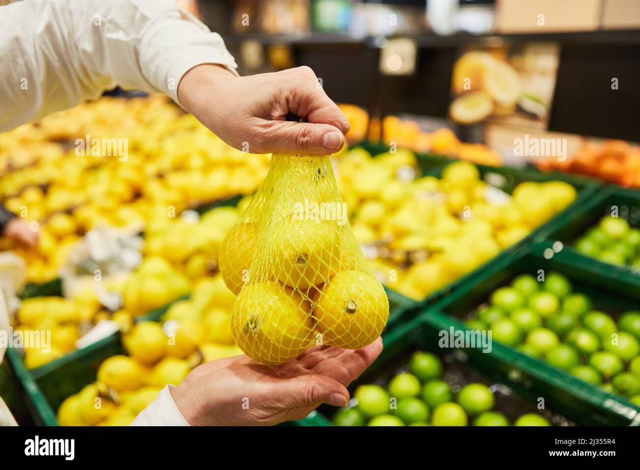 Hand of a customer at the fruit and vegetable stand in the supermarket ...