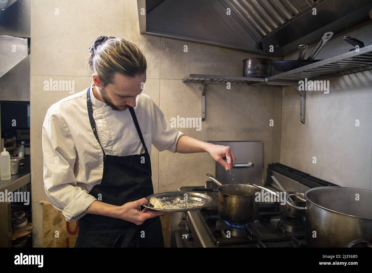 A Caucasian chef cooking Italian tortellini pasta in the kitchen Stock ...