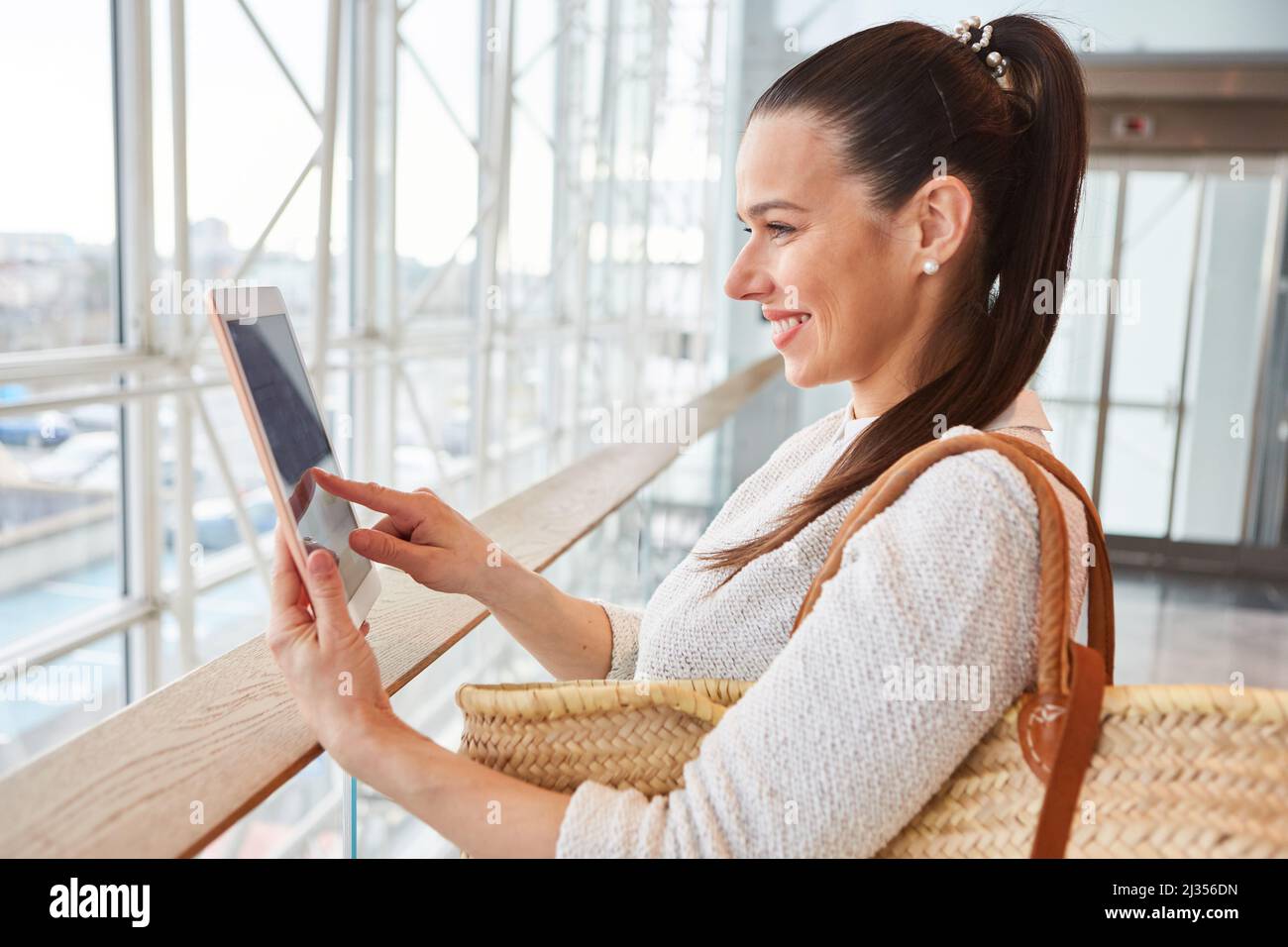 Woman with tablet computer shopping online and comparing prices in mall ...