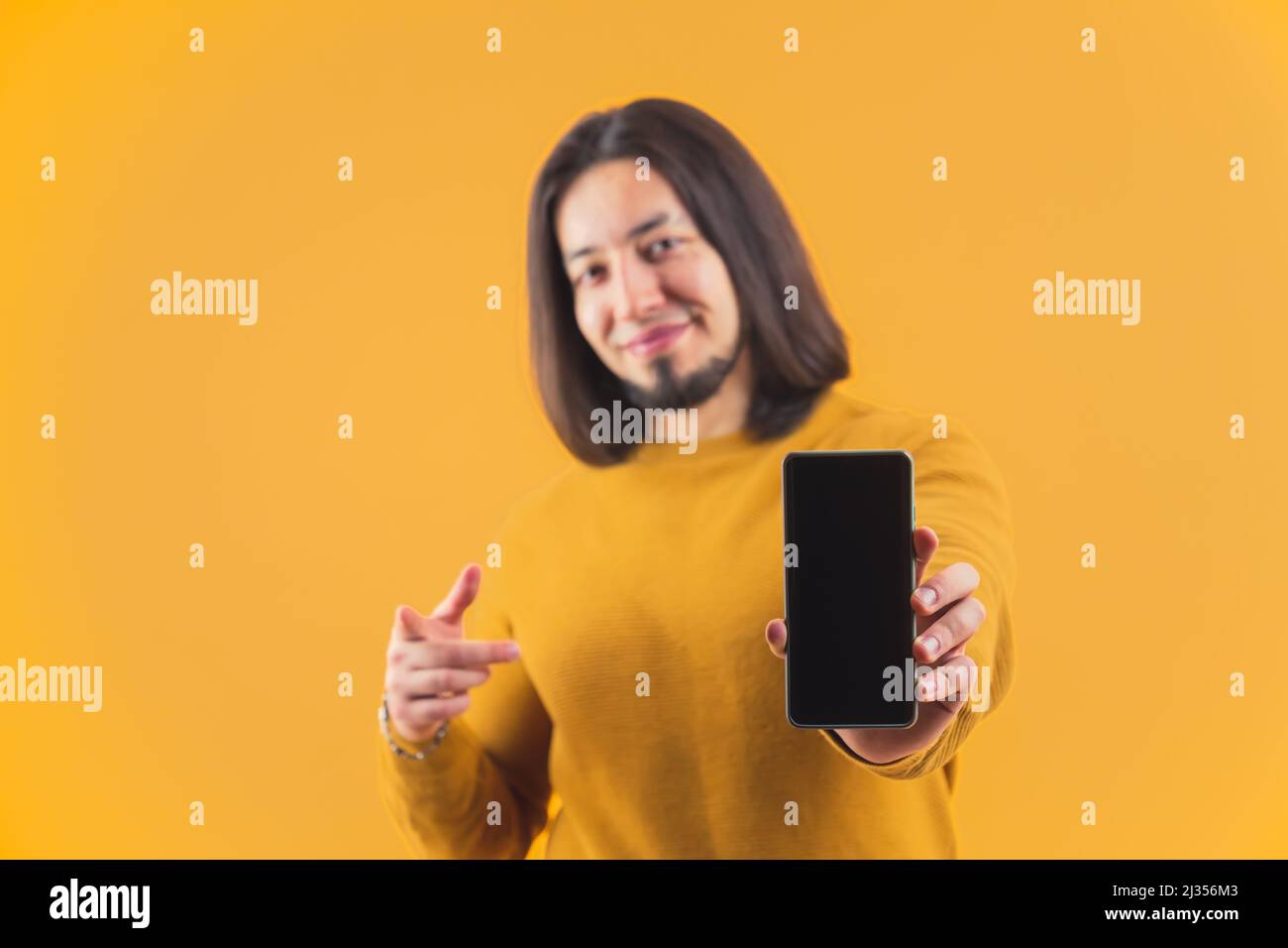 Cheerful bearded caucasian man showing his smartphone with blank screen ...