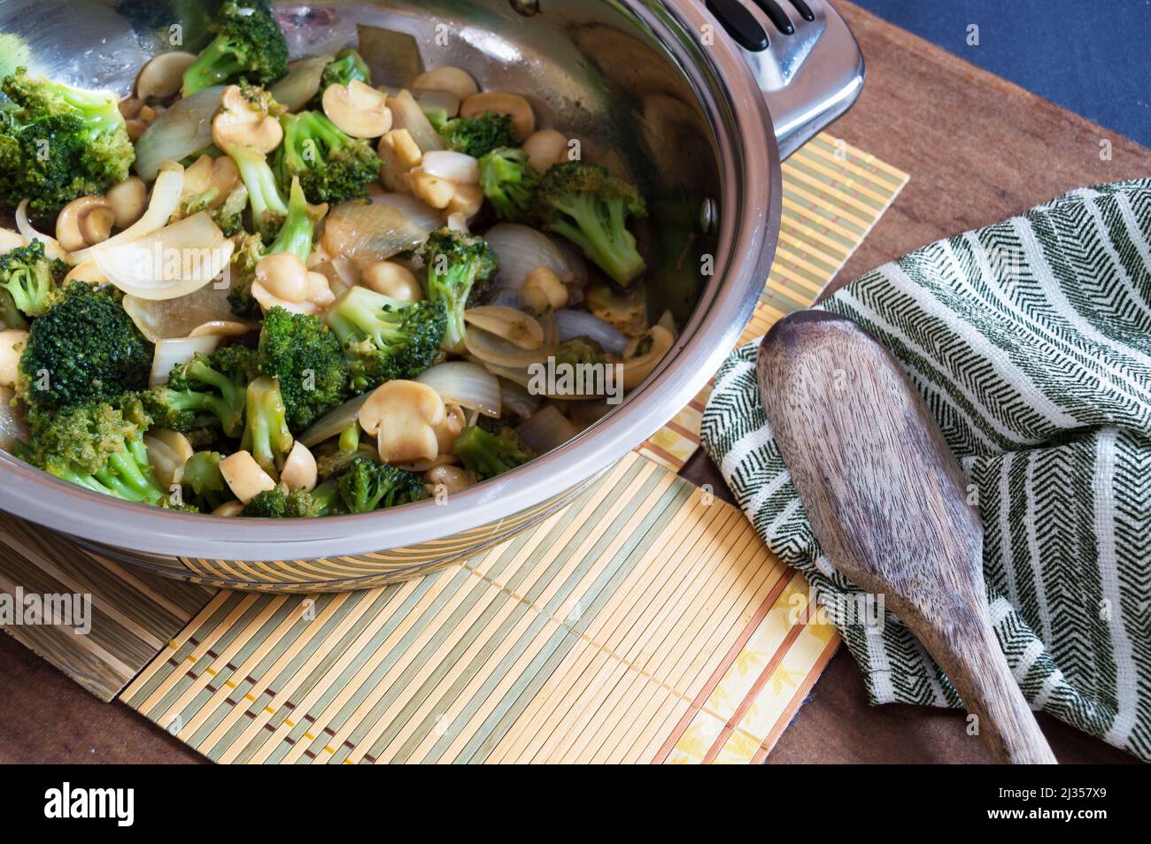 Frying pan with broccoli sautéed, mushrooms, sliced garlic and coarsely ...