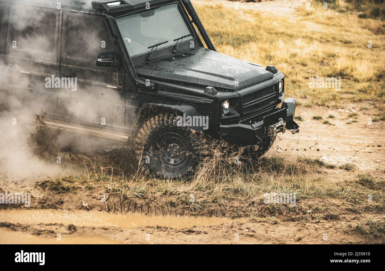 Low angle view of front of SUV on mountain road. Extreme off road tour ...