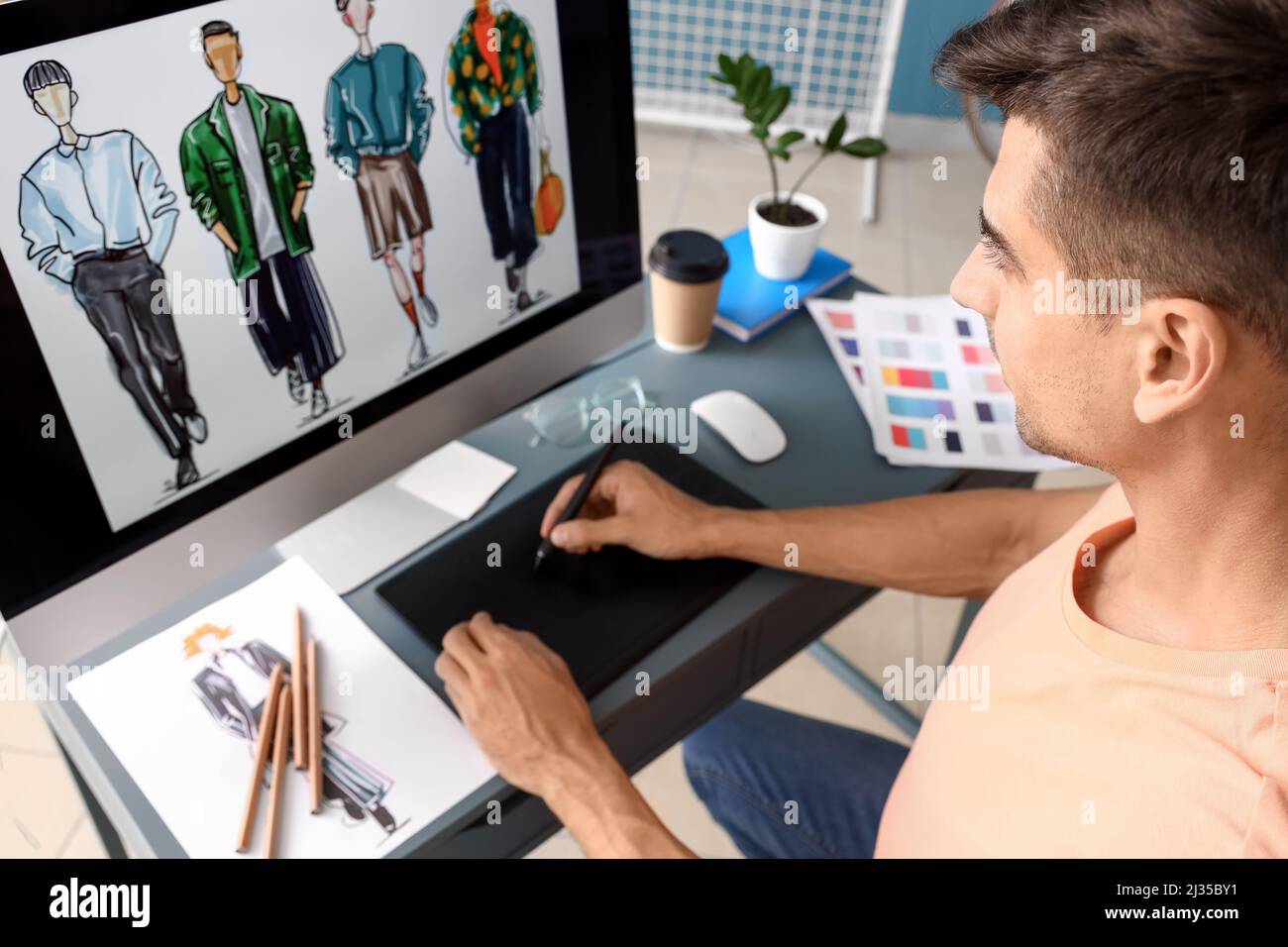 Male fashion designer working in studio Stock Photo - Alamy