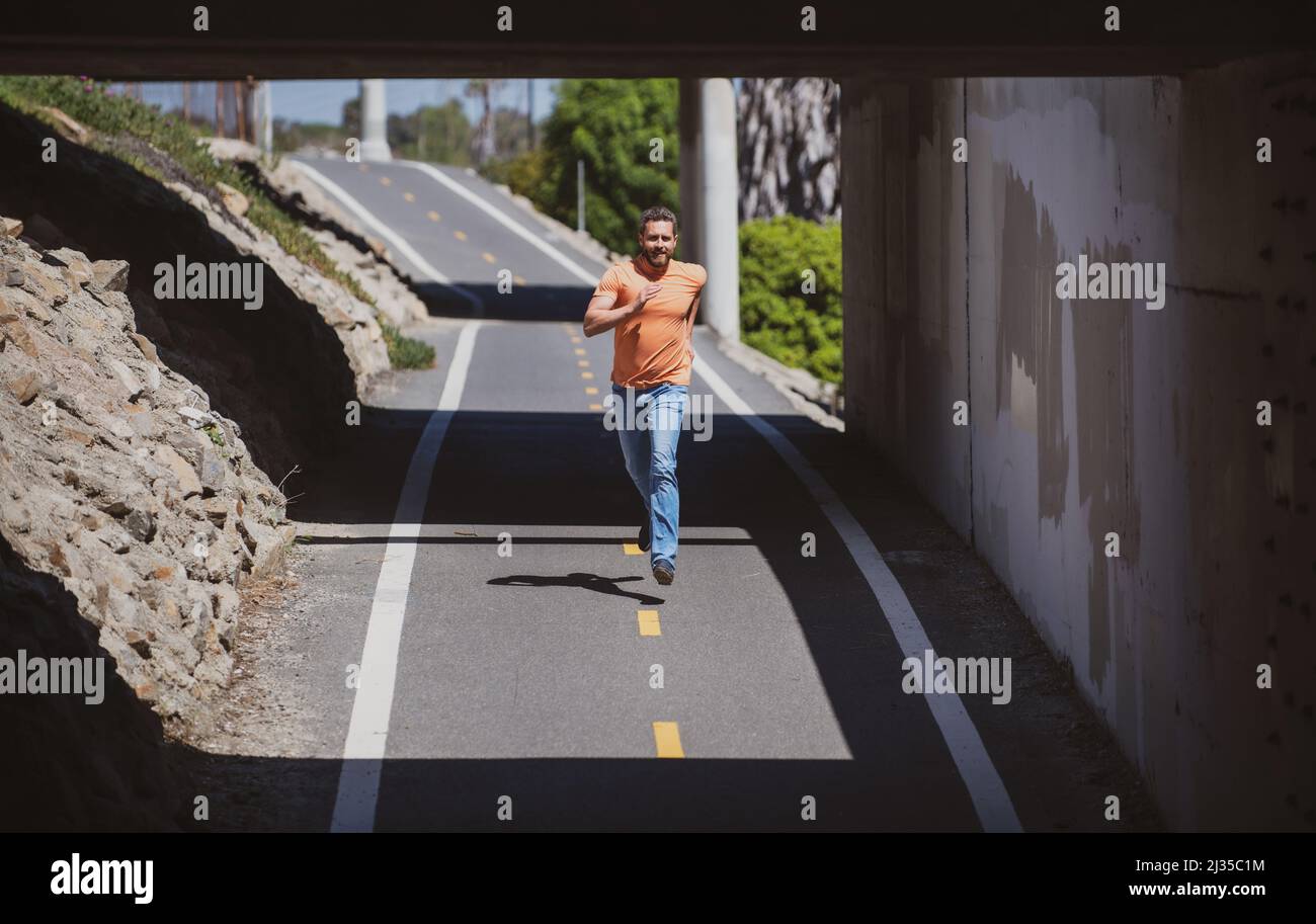 Full length of healthy man running and sprinting outdoors. Young ...