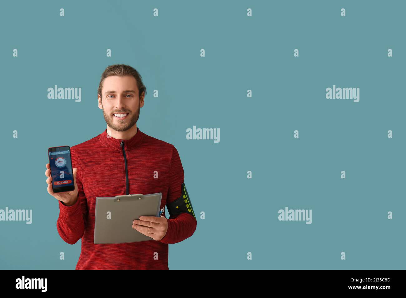 Sporty male coach holding phone with installed app for calories ...