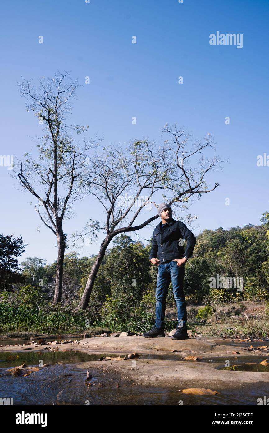 A man posing near a tree and river in India Stock Photo - Alamy
