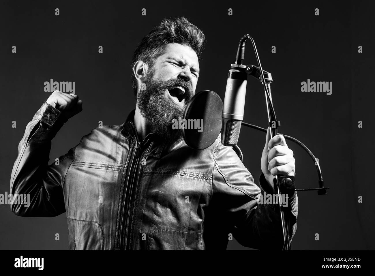 Man with microphone singing song. Musician in music hall. Expressive ...