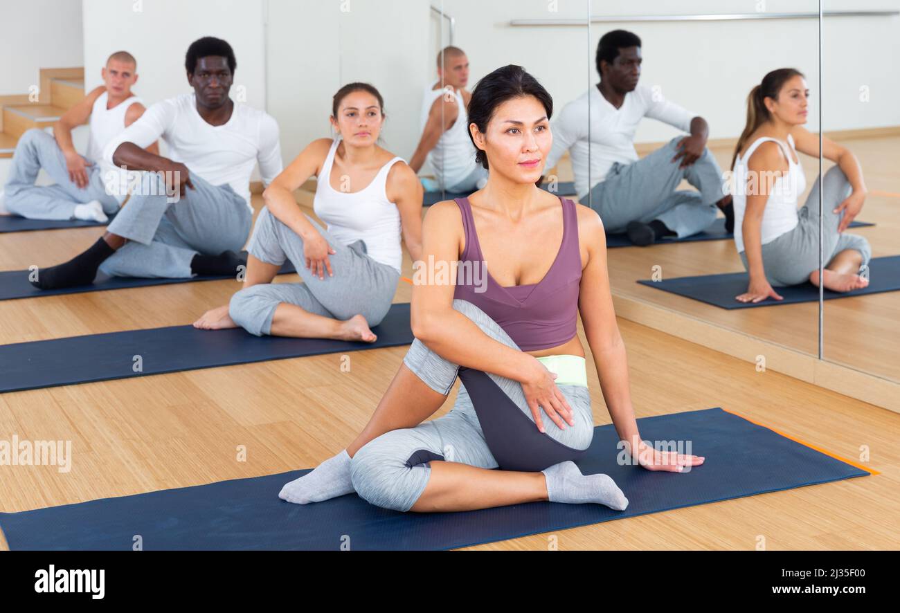 Focused Asian woman sitting in twisting asana Matsyendrasana Stock ...
