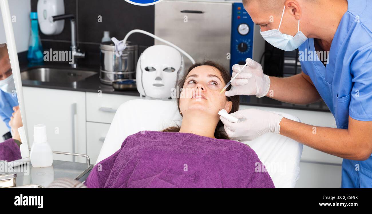 Female client during procedure of face mesotherapy in aesthetic ...