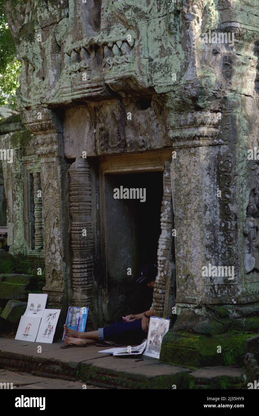 An artist waiting for customers to buy his drawings at Ta Prohm temple ...