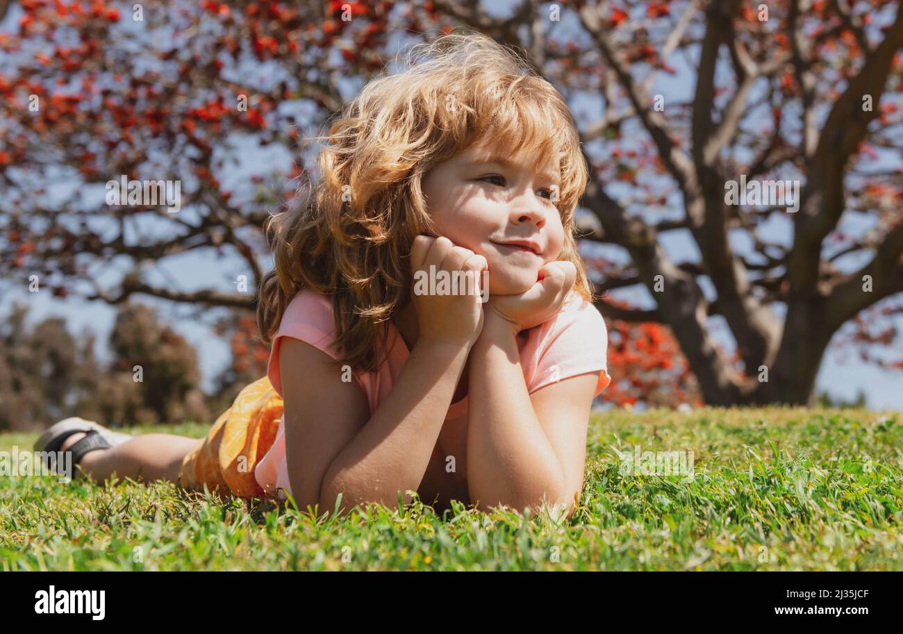 Kids face, little boy laying on grass Stock Photo - Alamy
