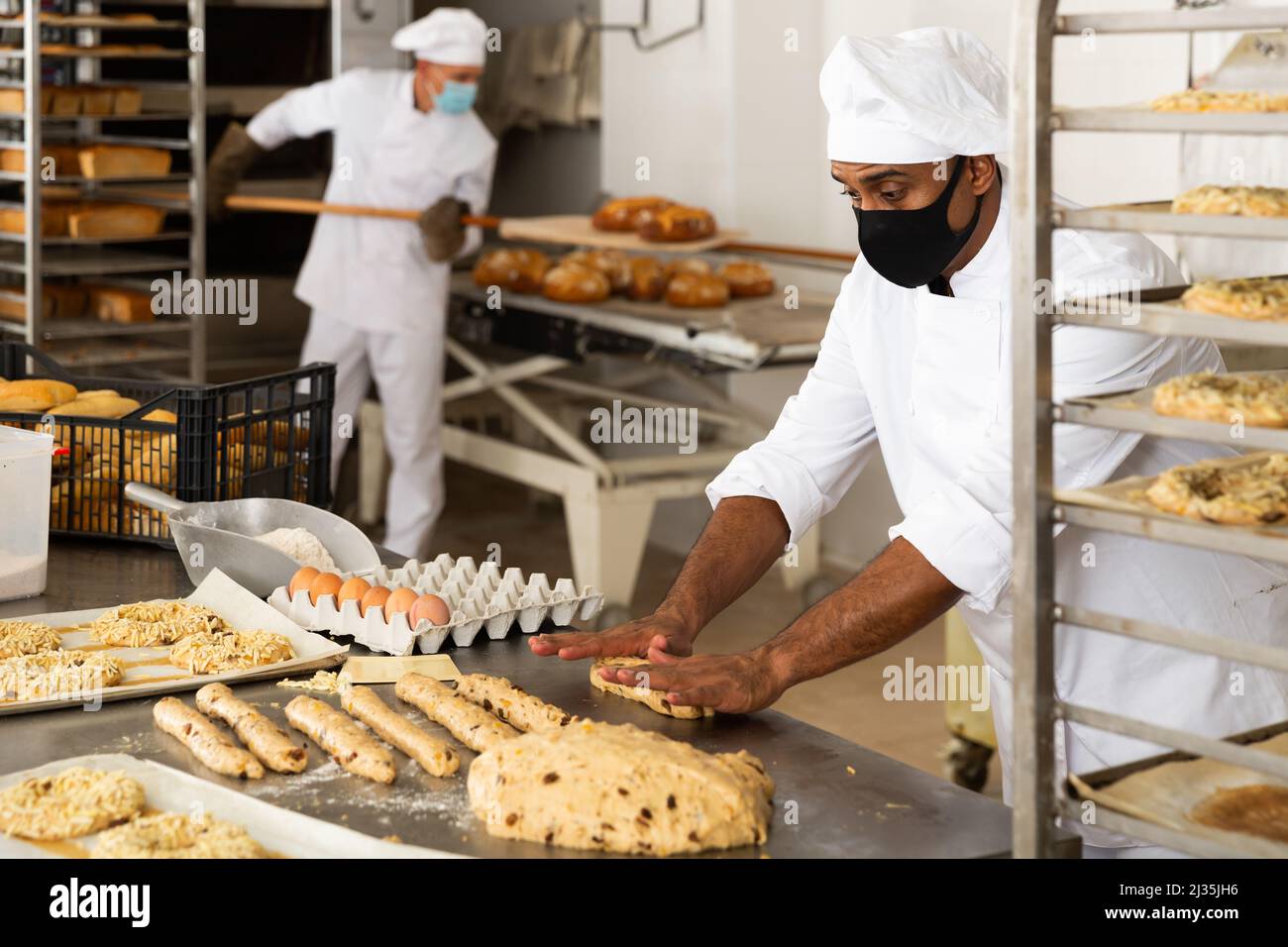 Male baker working with dough forming baguettes Stock Photo - Alamy