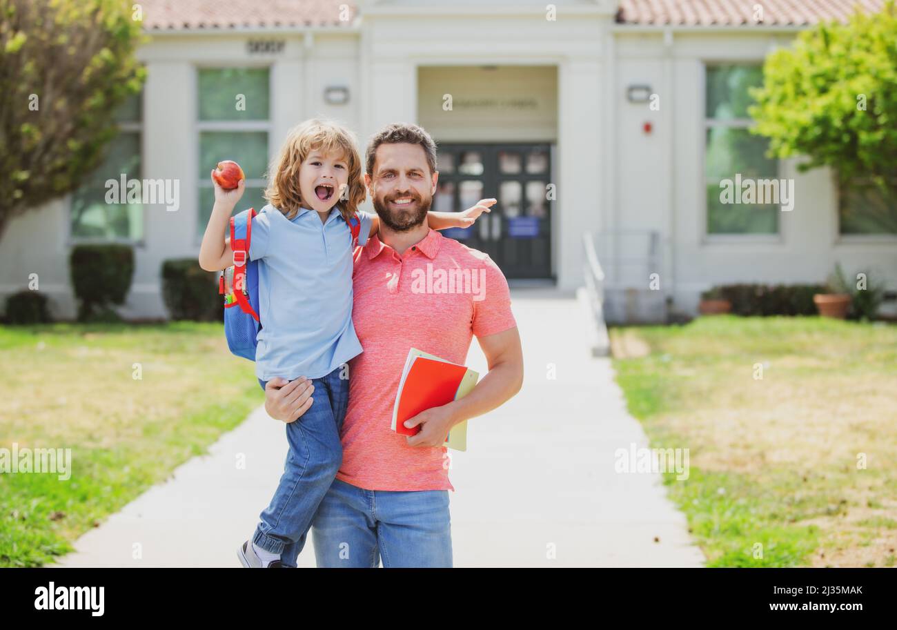 Father leads a little child school boy in first grade. Father supports ...