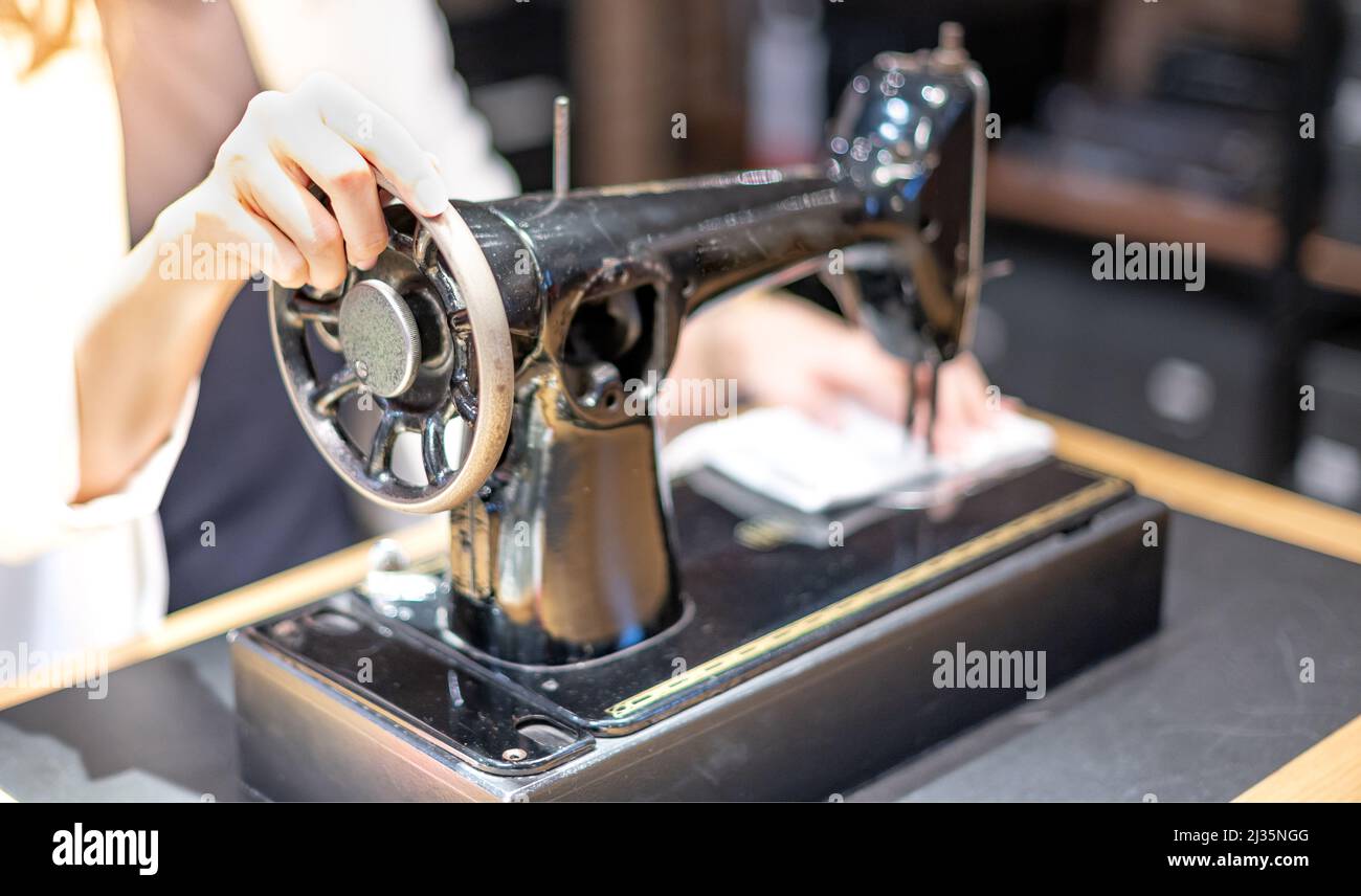 Female hand using vintage sewing machine scribbling fabric and ...