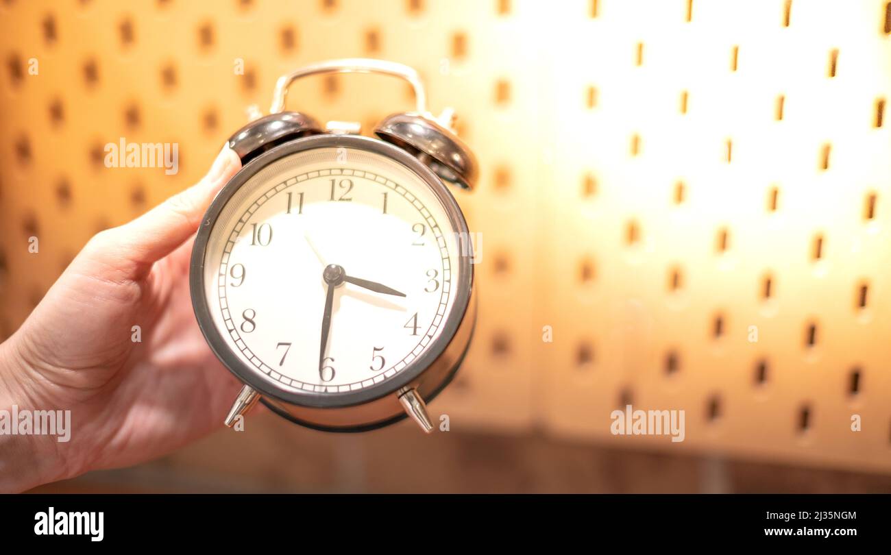 The classic black clock on the wooden backdrop shows the timing of life ...