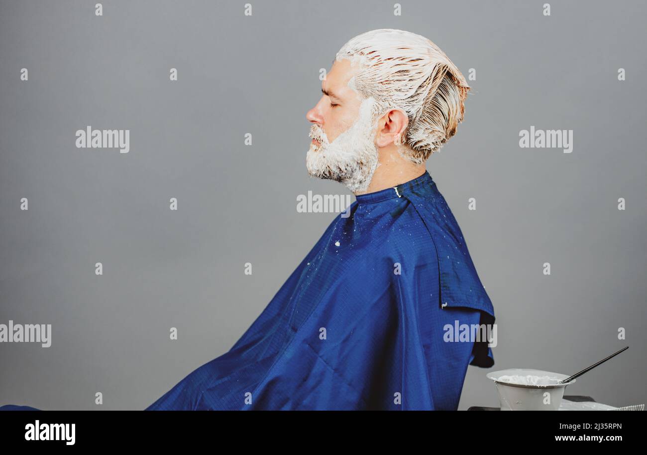 Barbershop. Portrait of bearded man color hair. Process of a man hair ...