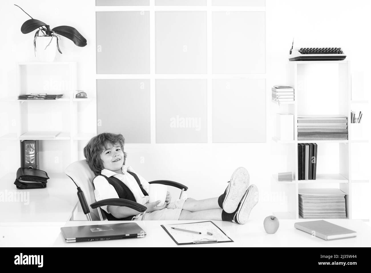 Office life. Little kid boy businessman wearing in formalwear reading ...