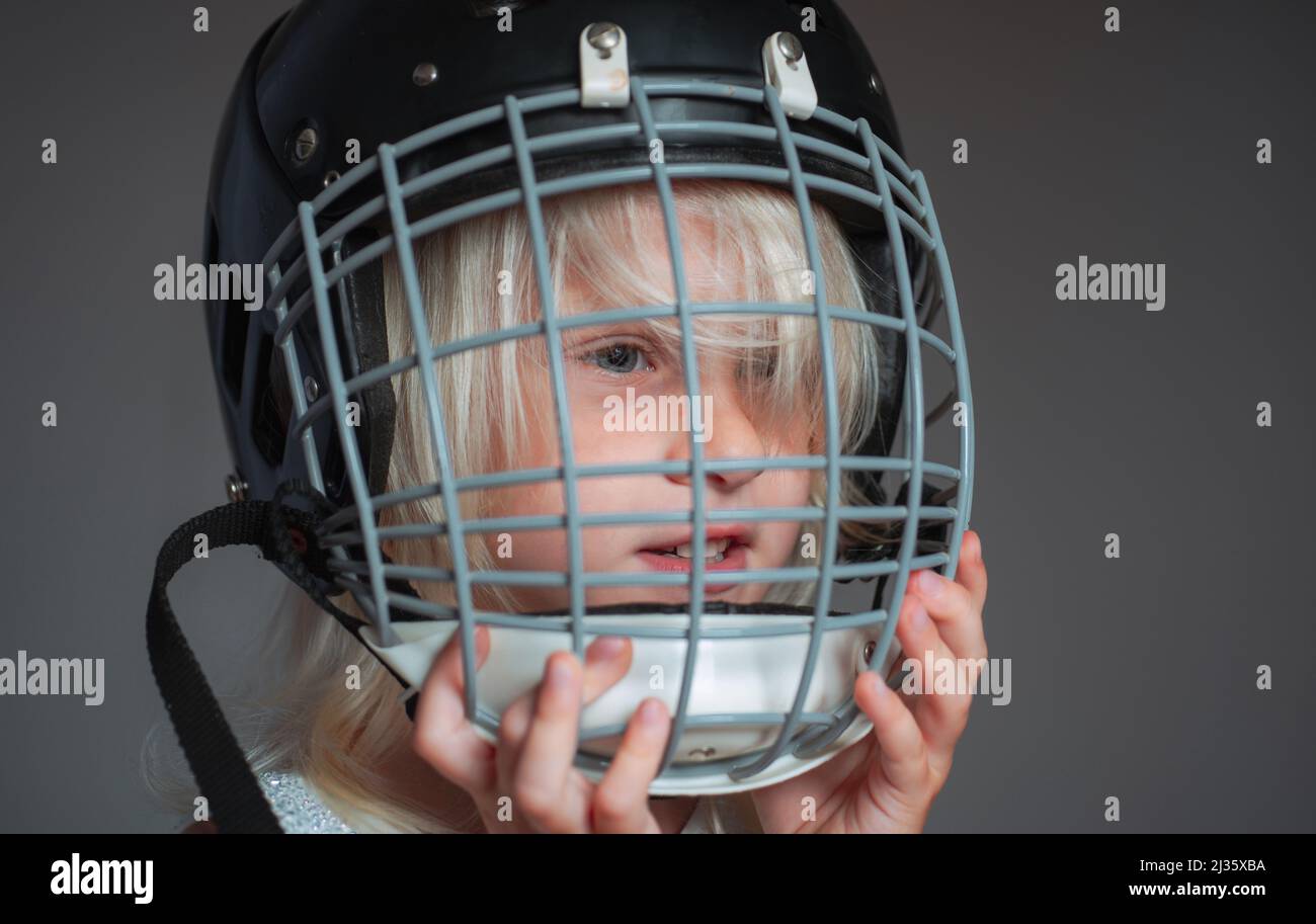 Sport upbringing and career. Girl cute child wear hockey helmet close ...