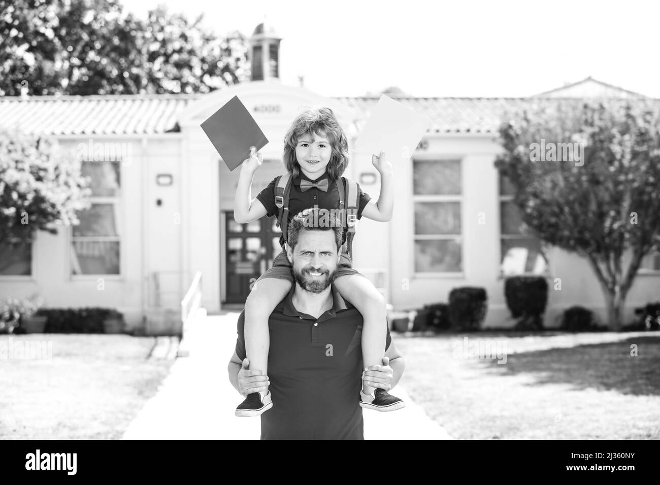 Outdoor school. Father giving son piggyback ride after school ...