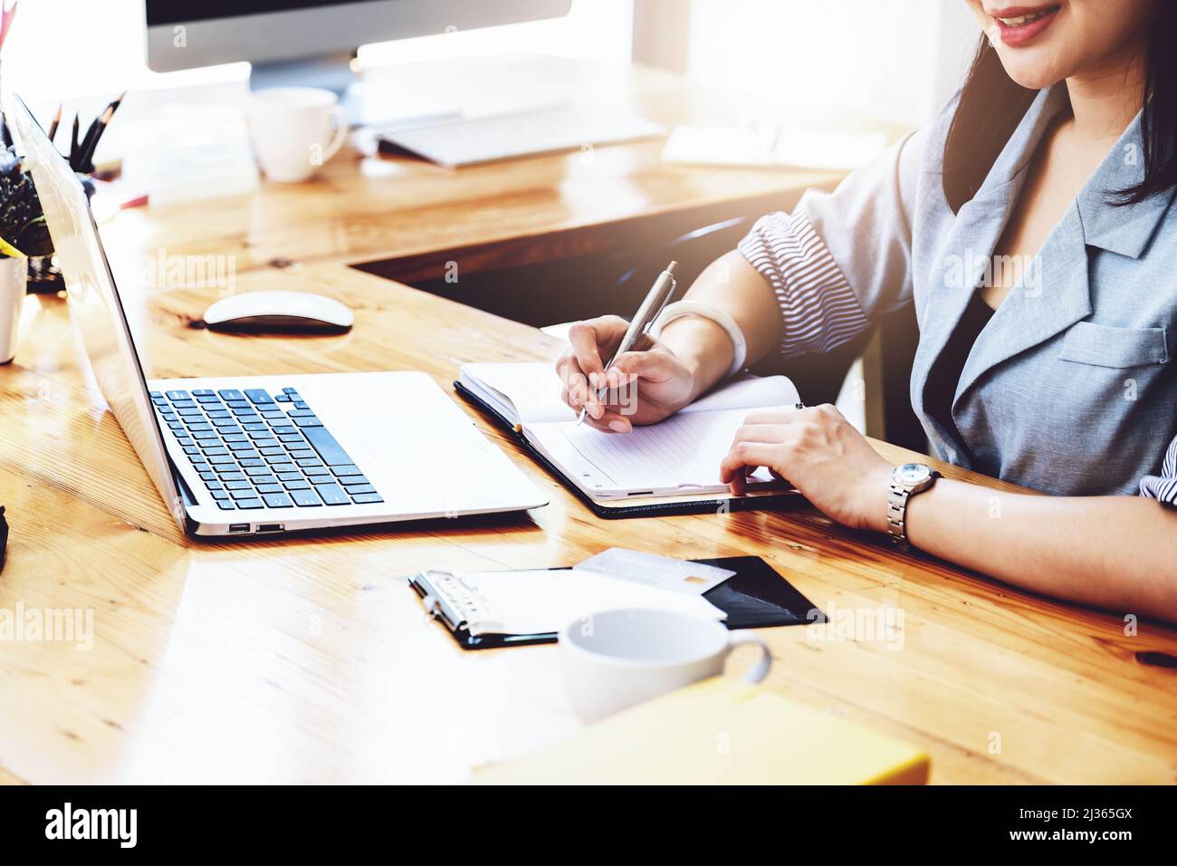 learning, note taking, planning, female employee holding a pen to write ...