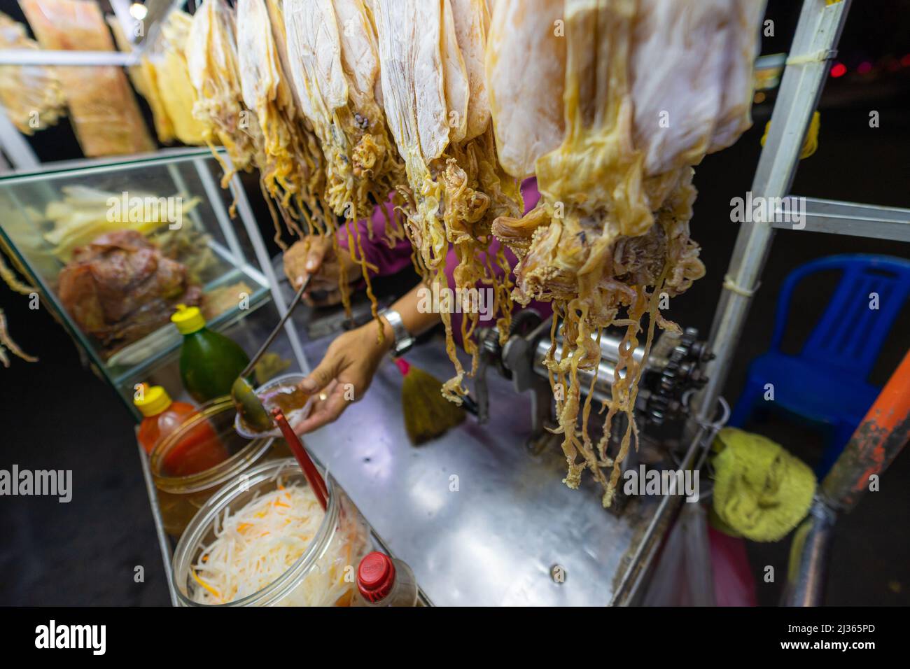 Traditional walking business selling dry squid on the street at night ...
