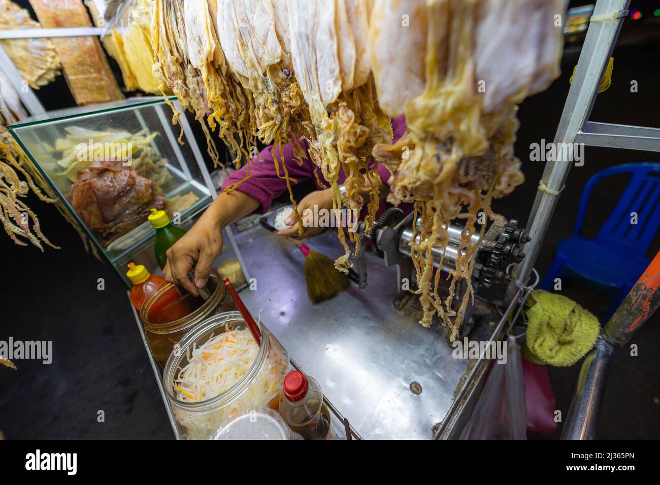 Traditional walking business selling dry squid on the street at night ...