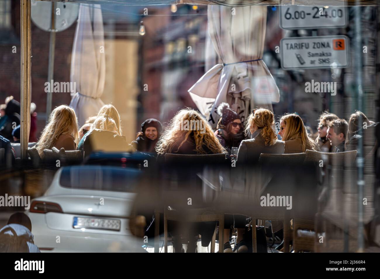 Riga, Latvia - April 2, 2022: Young women enjoy the first sunny days of ...
