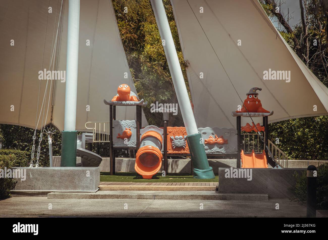 Shaded kid's playground activity tower equipment at park with a slide ...