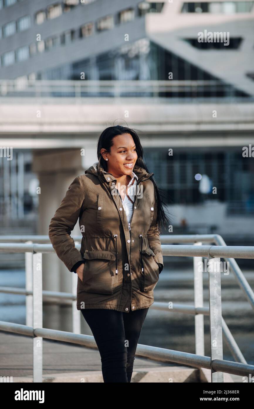 A young multiracial lady on a bridge in the modern residential district ...