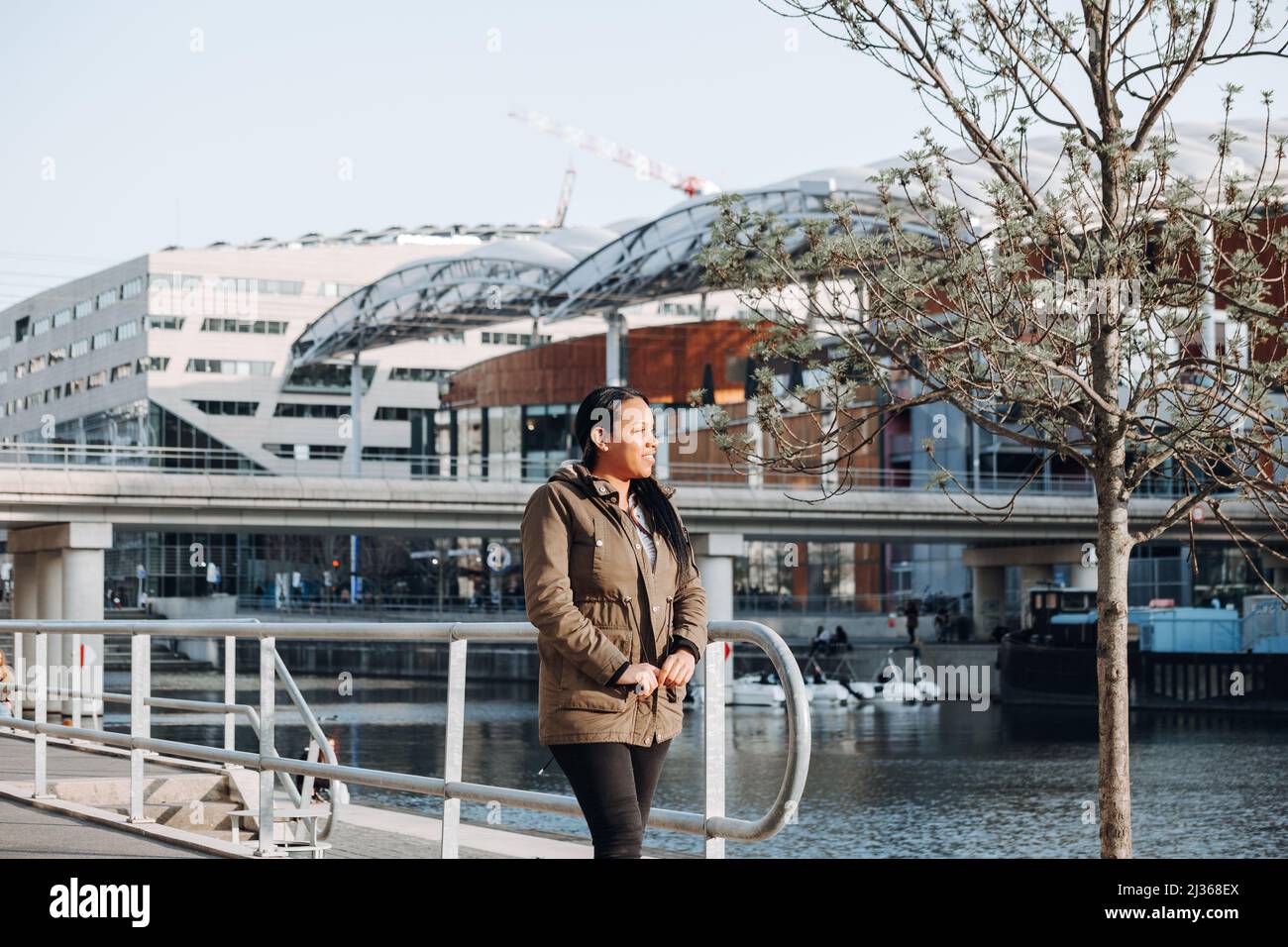 A young multiracial lady on a bridge in the modern residential district ...