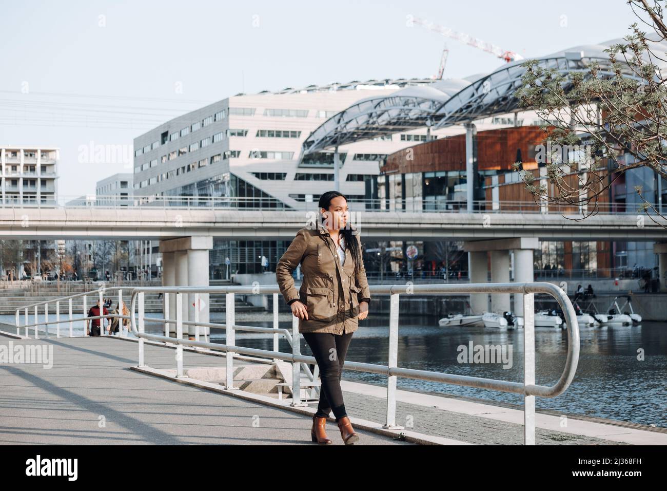 A young multiracial lady on a bridge in the modern residential district ...