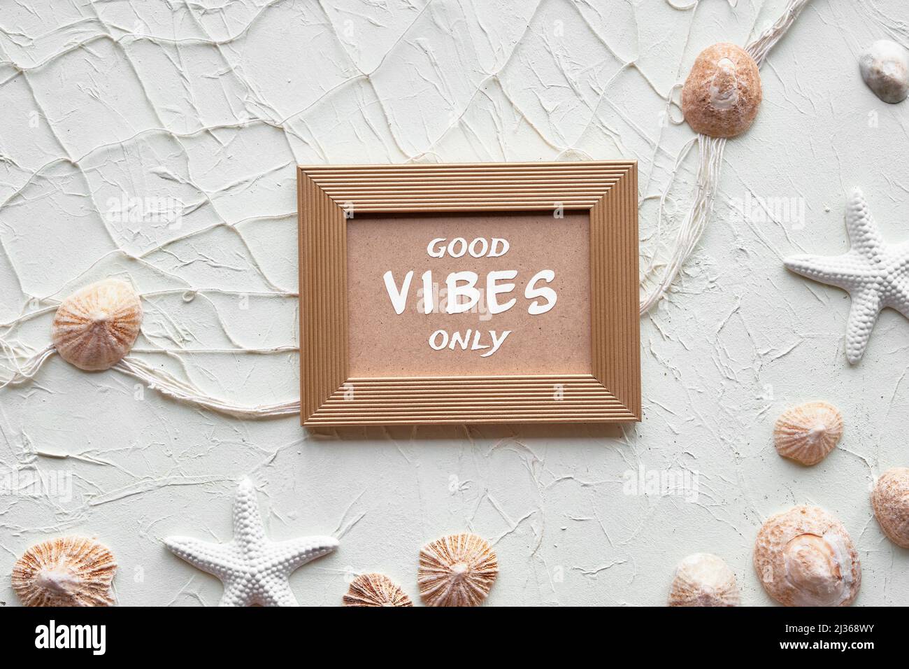 Text Good Vibes only in golden frame. Off white background with ...